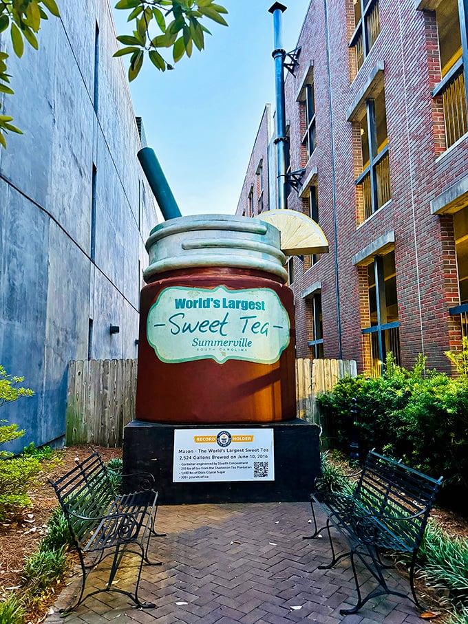 The World's Largest Sweet Tea stands proudly between brick buildings, complete with oversized straw and lemon slice—Southern hospitality supersized to Guinness-worthy proportions. 