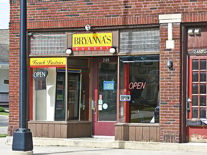 The bright yellow sign of Bryanna's Bakery stands out like a beacon of sweetness on Main Street, promising pastry perfection behind that unassuming brick facade.