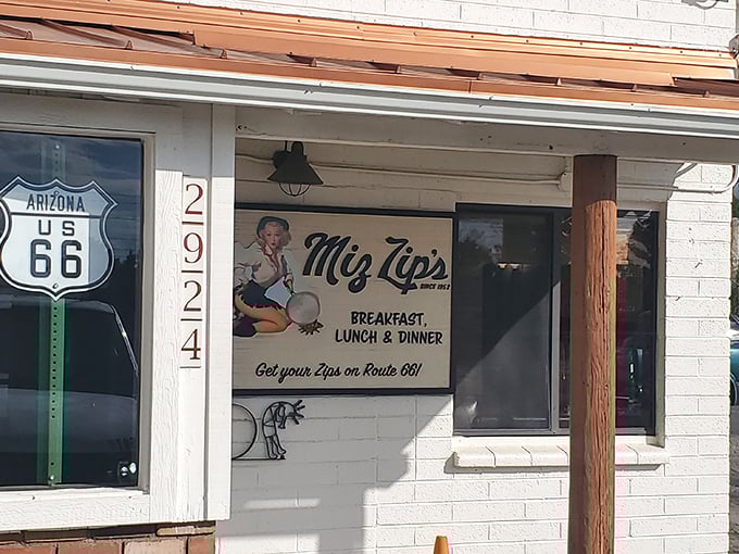 The promise of roadside bliss! Miz Zip's iconic Route 66 storefront beckons hungry travelers with its charming vintage sign and irresistible slogan.