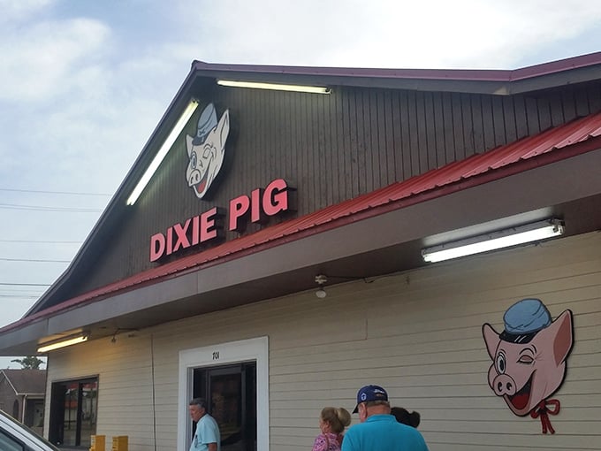 The winking cartoon pig on the sign isn't just cute—it's a promise of the smoky delights waiting inside this unassuming barbecue temple in Blytheville.