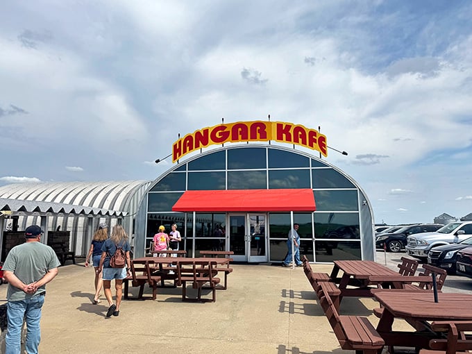Not your average storefront—this aviation-themed eatery announces itself with bold red letters and rustic outdoor seating, perfect for plane-spotting between pancake bites.