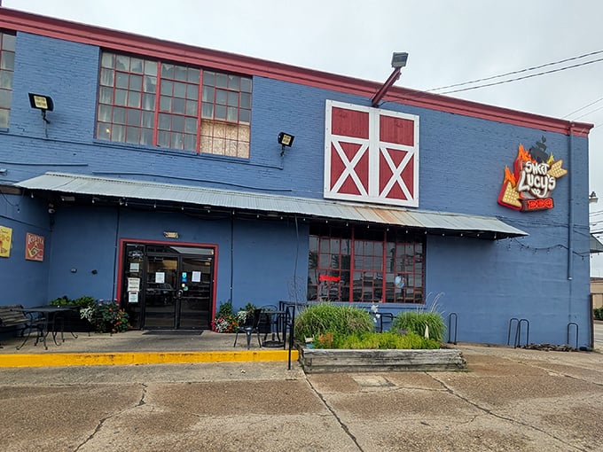 Sweet Lucy's distinctive blue building stands out like a beacon of hope for the hungry. Those stacked wood piles aren't just for show—they're flavor in waiting.
