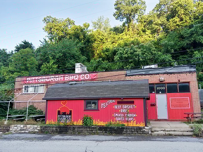 The bright red facade of Pittsburgh Barbecue Company stands out like a beacon of hope for hungry travelers. Painted flames promise what awaits inside: smoky perfection.