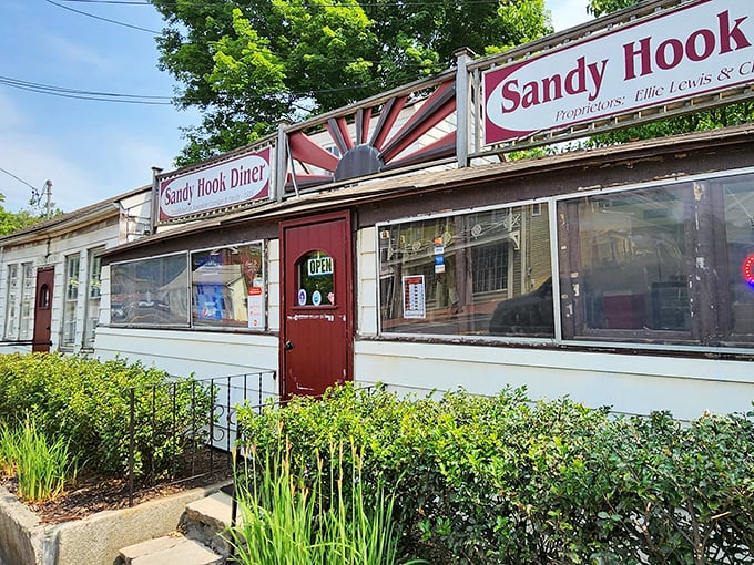 The classic roadside charm of Sandy Hook Diner beckons with its vintage sunburst sign and cozy exterior—a time capsule of Americana waiting to be discovered.