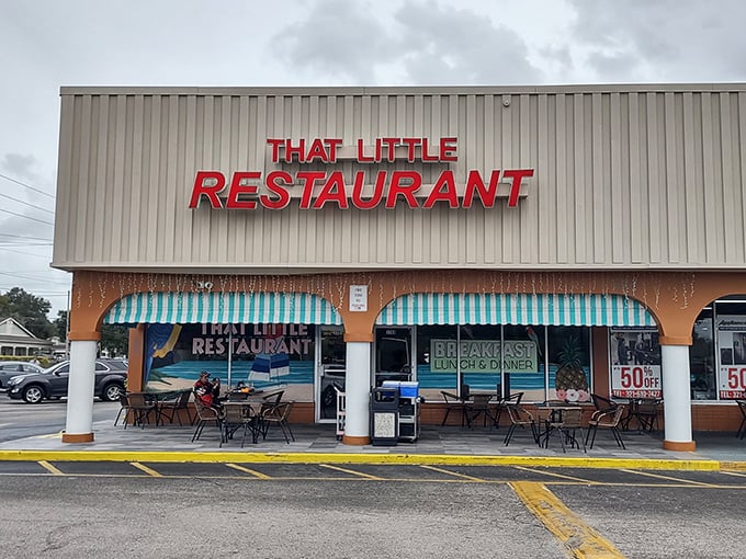 The bright red sign of That Little Restaurant stands out against the beige exterior, like a culinary lighthouse beckoning hungry travelers to safe harbor.