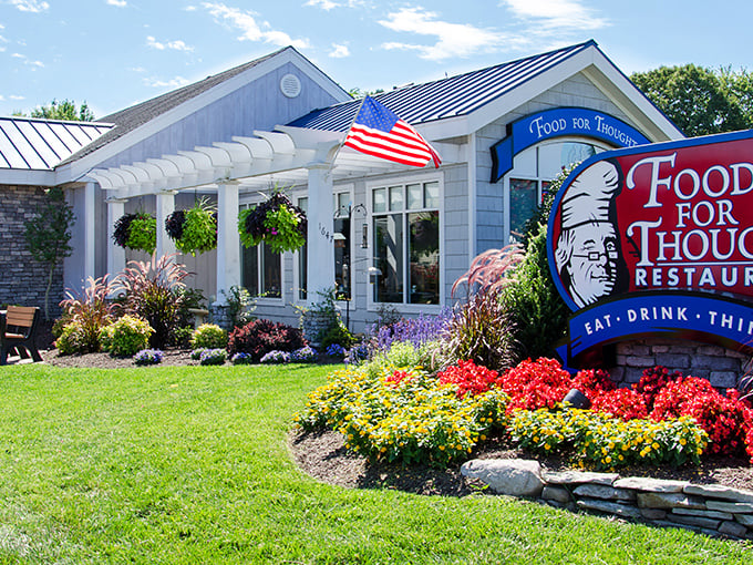 The charming exterior of Food For Thought welcomes visitors with colorful flower beds and a distinctive sign that promises more than just a meal.