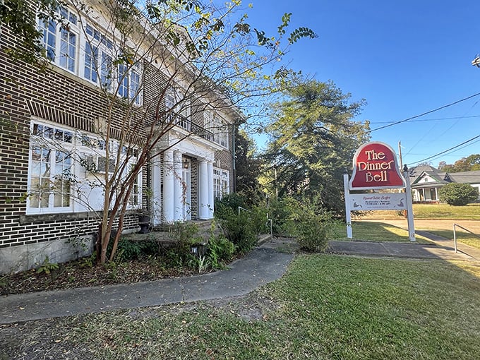 The Dinner Bell's stately brick exterior and white columns aren't just Southern charm – they're the gateway to a fried chicken paradise hiding in plain sight.