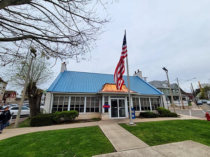 The iconic blue roof and American flag announce your arrival at breakfast paradise. This unassuming building houses morning magic that locals have treasured for years.