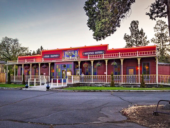 The Wild West meets culinary excellence at Tumalo Feed Company's iconic red exterior. Those hanging flower baskets aren't just for show—they're welcoming you to steak paradise.