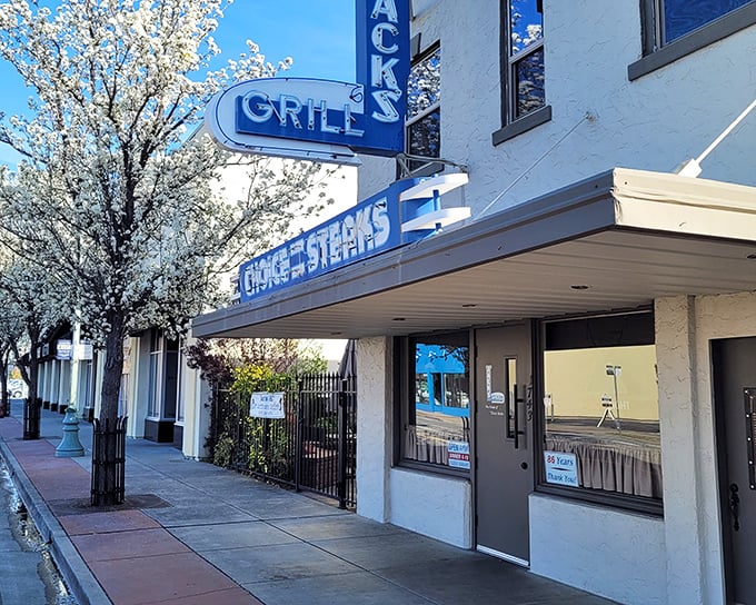 Spring blossoms frame Jack's iconic blue signage, a reminder that some California treasures bloom year-round, especially those serving perfect steaks.
