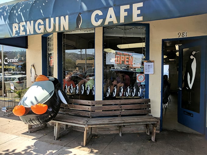 The iconic blue awning of Penguin Cafe stands out like a beacon of breakfast hope on Laguna Beach's Coast Highway, complete with an inflatable penguin sentinel.