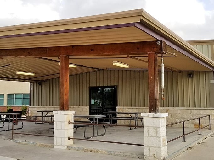 The covered patio at Baker Boys BBQ offers a shaded respite from the Texas sun, where picnic tables await hungry pilgrims seeking smoky salvation.