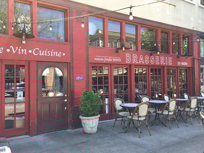 The iconic burgundy façade of Brasserie by Niche beckons from the sidewalk, those blue-striped bistro chairs practically whispering, "Bonjour, hungry traveler!"