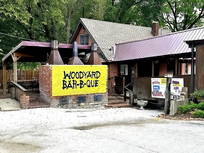 That bright yellow sign against the rustic wooden structure is like a beacon calling to barbecue pilgrims. No fancy frills, just smoke signals of deliciousness ahead.