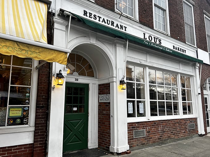 The green and white awning of Lou’s Restaurant & Bakery stands like a promise on Hanover’s Main Street—a signal that comfort food and sweet indulgence await just inside.