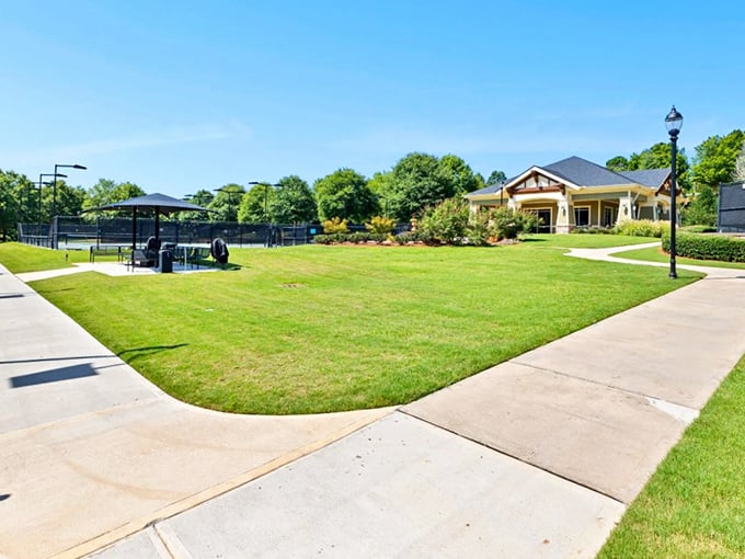 Tennis courts and clubhouse bathed in Georgia sunshine—where retirement means upgrading your backhand, not downgrading your lifestyle.
