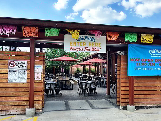 Colorful papel picado banners flutter above the entrance, a festive invitation to the cheese-laden paradise that awaits inside.