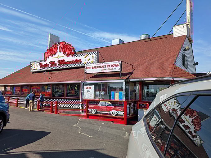 The classic red-roofed diner with its checkered trim stands like a time machine disguised as a restaurant. Welcome to flavor paradise!