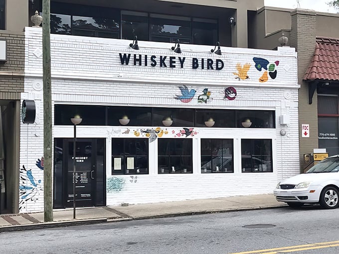 The colorful bird murals adorning Whiskey Bird's white brick façade aren't just decoration—they're a promise of the vibrant flavors waiting inside this Atlanta gem.