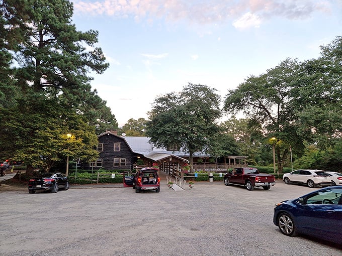 The rustic log cabin exterior of Sconyers Bar-B-Que stands like a barbecue beacon among Georgia pines, promising smoky delights within.