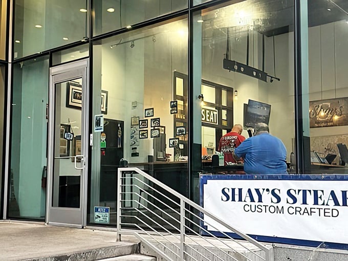 The storefront beckons with that hypnotic blue neon glow—like a lighthouse guiding hungry sailors through Philadelphia's sandwich seas.