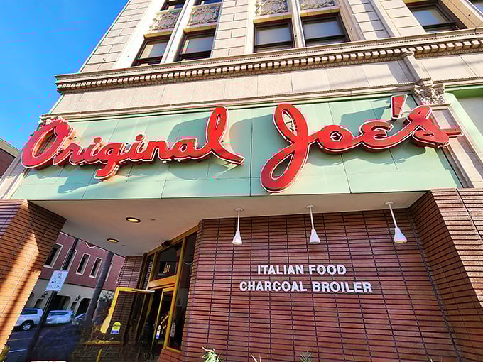 The iconic red script of Original Joe's glows like a beacon for hungry souls wandering downtown San Jose, promising Italian-American comfort in neon form.