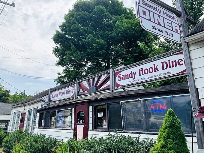 The classic roadside charm of Sandy Hook Diner beckons with its vintage sunburst sign and cozy exterior—a time capsule of Americana waiting to be discovered.