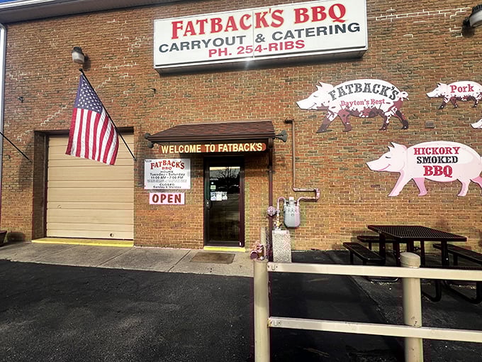 The brick exterior of Fatback's BBQ welcomes hungry visitors with playful pig silhouettes and an American flag—a carnivore's embassy on Dayton soil.