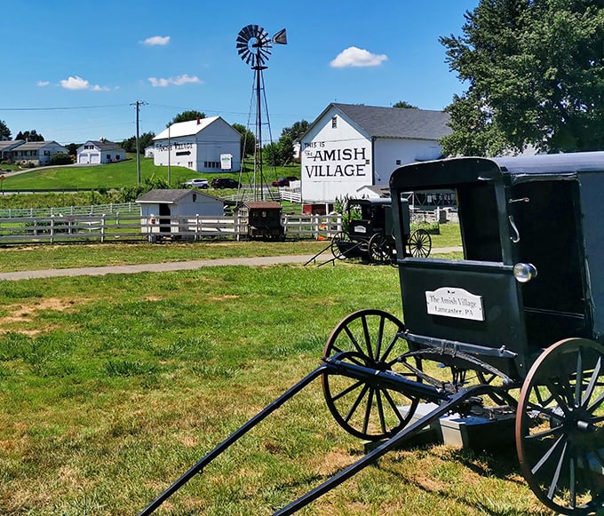 The iconic windmill and traditional Amish buggy greet visitors, a perfect postcard moment of simpler times against Pennsylvania's blue skies.