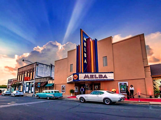 The Melba Theater glows with vintage charm at sunset, its neon sign a beacon of affordable entertainment that's outlasted countless streaming subscriptions.