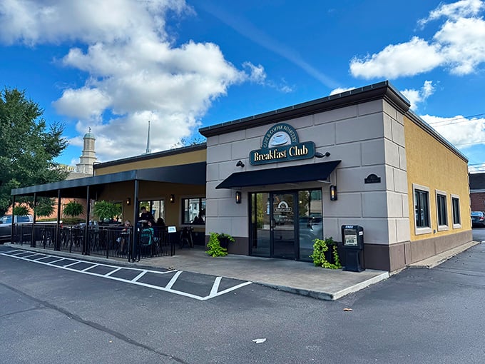 Another angle reveals the restaurant's welcoming facade, where hungry patrons gather under blue skies. The church steeple in the background adds small-town charm.