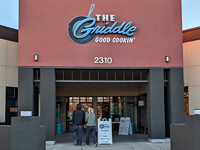 The Griddle's exterior promises "Good Cookin'" – perhaps the breakfast understatement of the century. That blue neon sign beckons like a lighthouse for the hungry and caffeine-deprived.