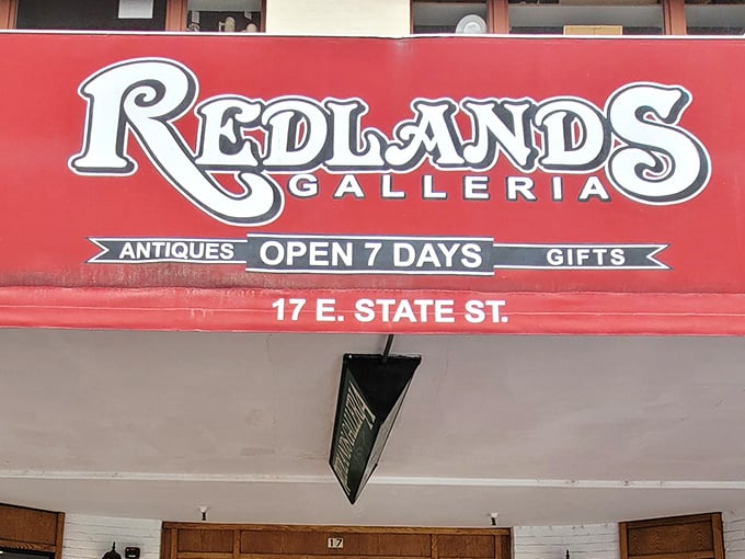 The welcoming facade of Redlands Galleria beckons treasure hunters with its vintage cart display and warm wooden entrance. Time travel begins here!