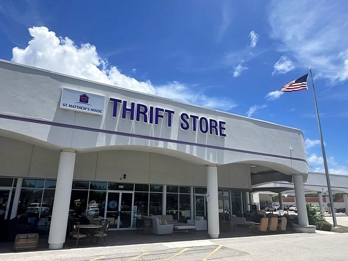 The purple-trimmed facade of St. Matthew’s House Thrift Store stands proudly against the Florida sky, a beacon for bargain hunters with champagne taste on a root beer budget.
