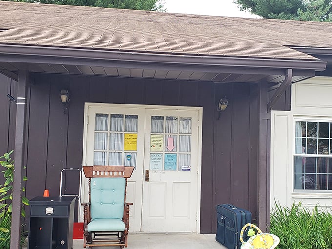 The unassuming entrance with its vintage rocking chair is like a secret handshake – only thrift store aficionados recognize the promise that lies beyond those white doors.