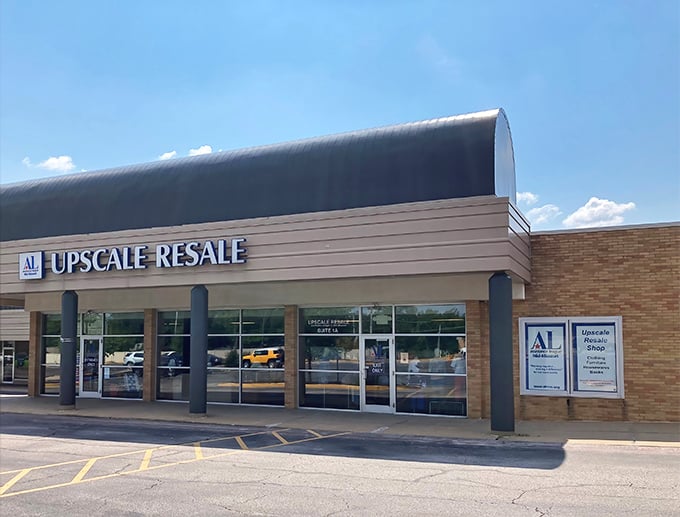 The distinctive curved roof and clean storefront of Upscale Resale beckons bargain hunters like a retail oasis in the Missouri shopping desert.