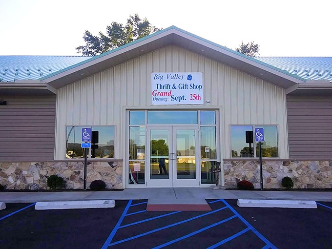The welcoming facade of Big Valley Thrift & Gift Shop beckons treasure hunters with its stone base and distinctive green metal roof.