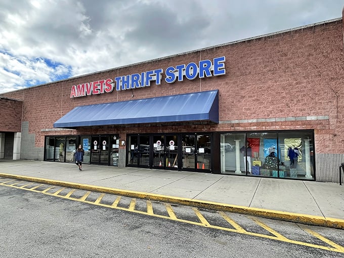 The unassuming brick exterior of AMVETS Thrift Store beckons with its bold blue signage, promising treasure hunters adventures that await just beyond those glass doors.