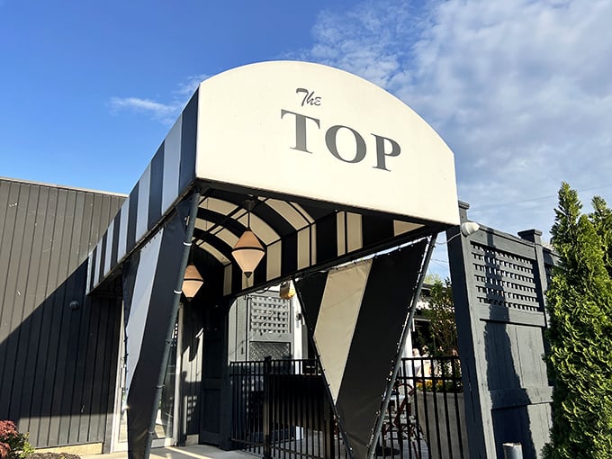 The iconic black and white striped entrance to The Top Steakhouse stands like a mid-century modern beacon for hungry Ohioans.