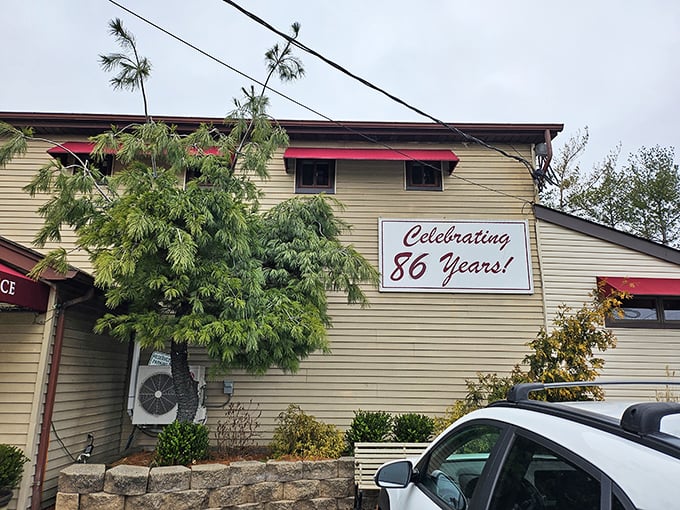 A humble beige exterior with red awnings and a "Celebrating 86 Years!" sign – proof that culinary greatness doesn't need flashy architecture.