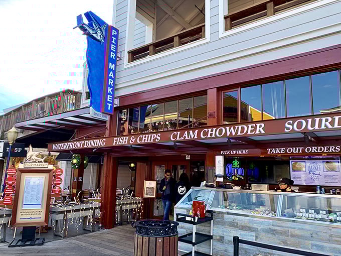 The blue vertical sign beckons hungry visitors like a lighthouse for the famished. "Fish & Chips" and "Clam Chowder" – six magic words that promise maritime delights.