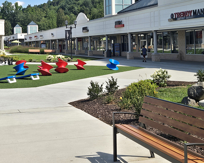 The pristine walkways of Pocono Premium Outlets invite shoppers with colorful sculptures and comfortable benches—retail therapy with mountain air included.