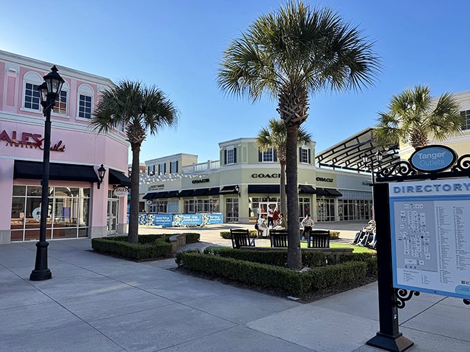The iconic entrance to Tanger Outlets Charleston, where palm trees and colonial architecture create a shopping paradise that feels distinctly Southern yet universally appealing.