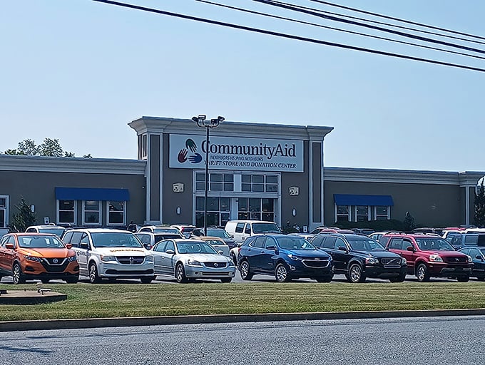 The welcoming facade of CommunityAid beckons with its colorful handprint logo—like a high-five promising bargains inside.