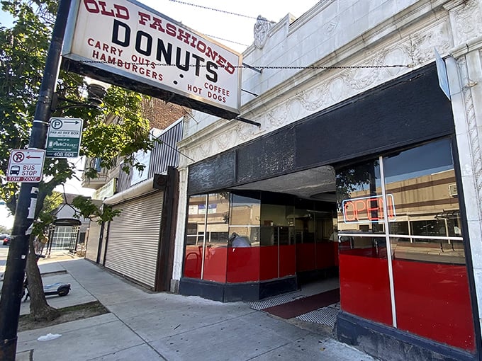 Sunlight catches the vintage signage promising simple pleasures – donuts, coffee, and the comfort of culinary consistency in an ever-changing world.
