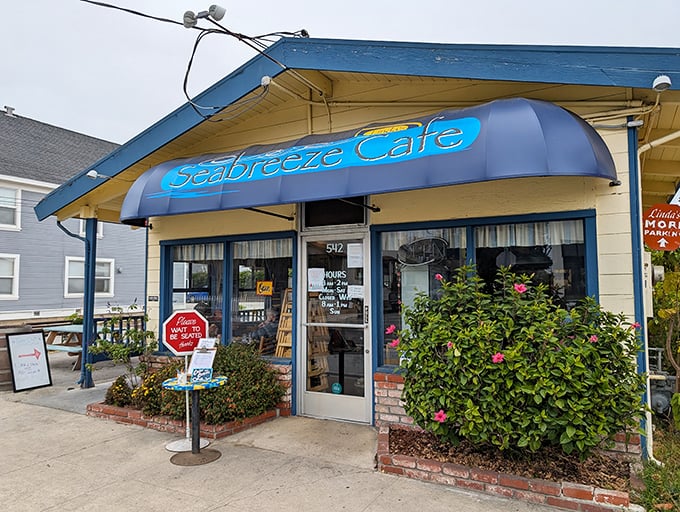 The little blue building with the bright awning isn't trying to impress anyone—until you taste what's coming out of the kitchen.