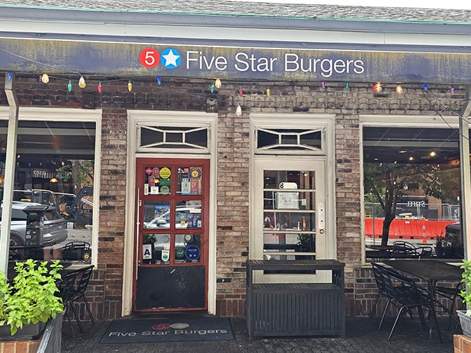 The charming brick exterior of 5 Star Burgers welcomes you with string lights and lush planters—like that friend whose house always feels more inviting than yours.