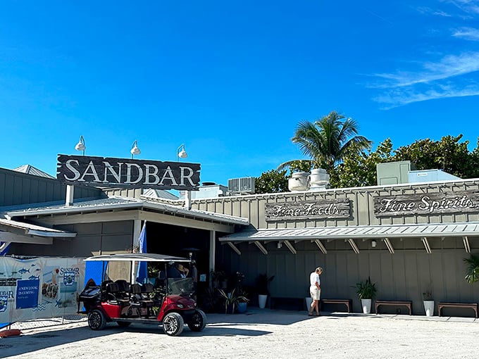 Daytime reveals The Sandbar's casual coastal charm, where golf carts park alongside dreams of perfect grouper sandwiches.