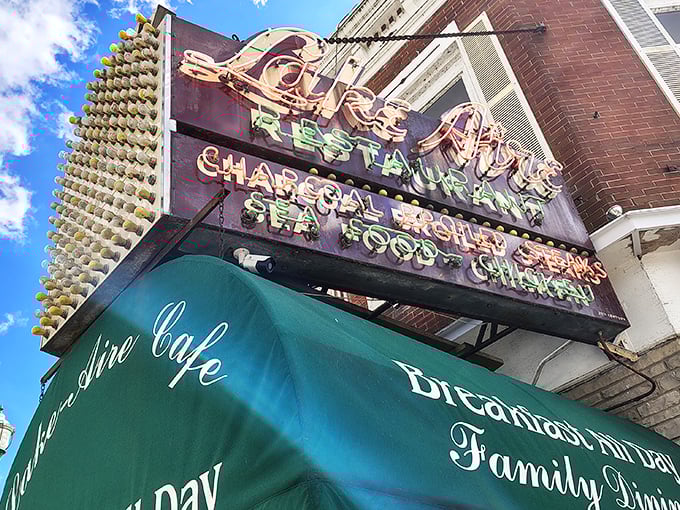 That vintage neon sign says it all – charcoal steaks, seafood, and chicken. Like a beacon calling hungry travelers home since before Instagram food pics were a thing.
