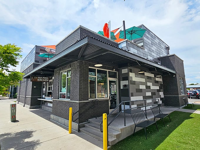 The modern brick exterior of Four Friends Kitchen stands like a culinary lighthouse in Denver's Stapleton neighborhood, complete with a rooftop patio that beckons brunch enthusiasts.